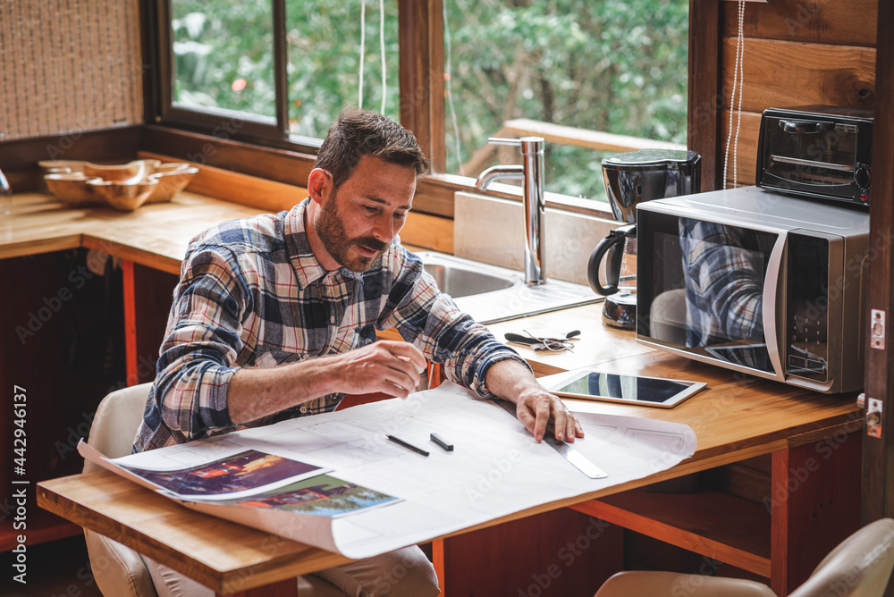 Busy man drawing draft of house at home Stock Photo | Adobe Stock