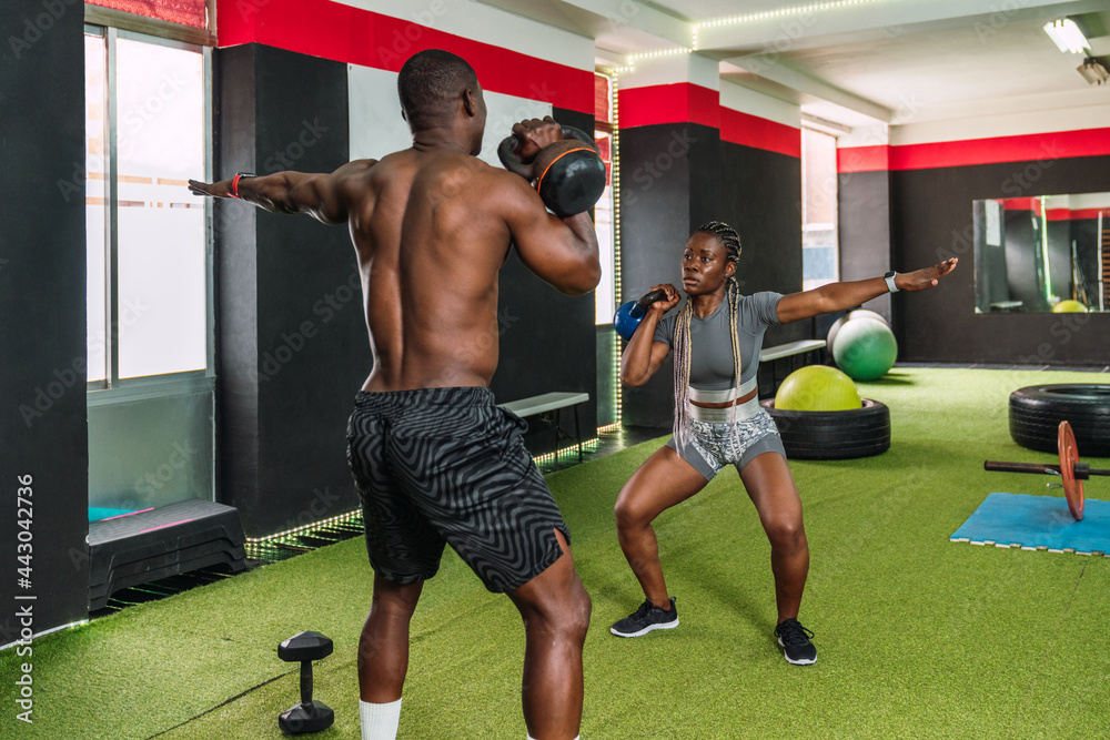two African bodybuilder athletes doing toning exercises for biceps and ...