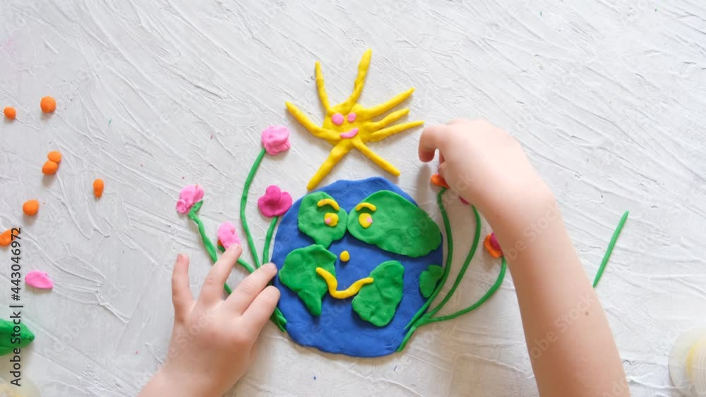 Child sculpturing plasticine planet for earth day. Protection of ...