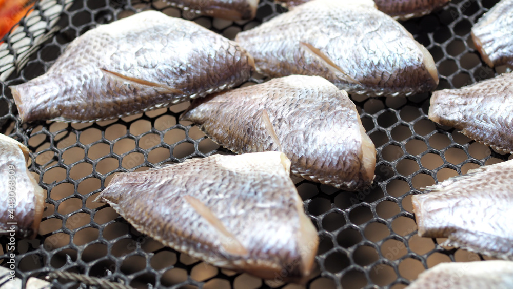 Preservation tilapia fish with sunbathe, dried and cutting head to ...