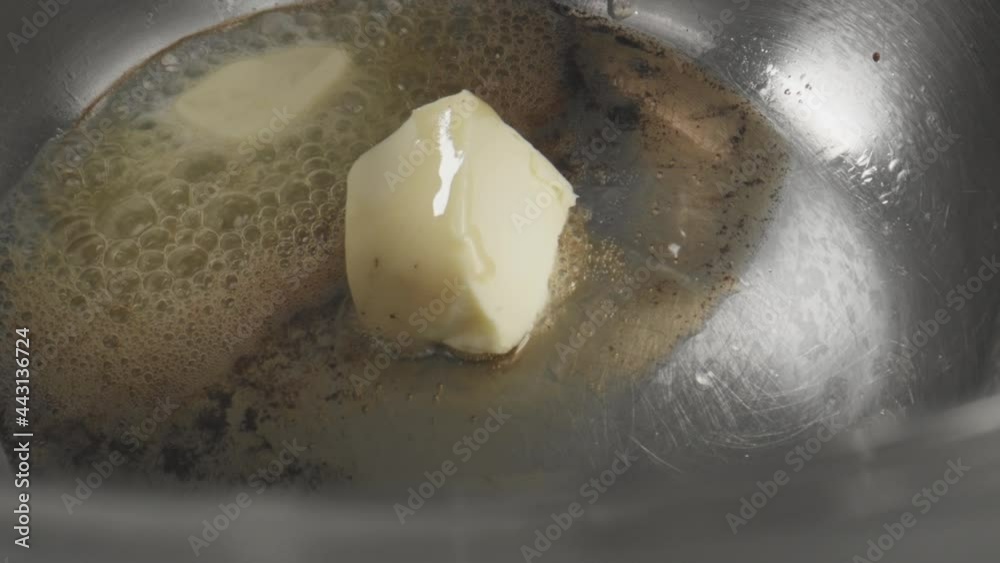 A piece of butter falls into the pan. One of the stages of cooking ...