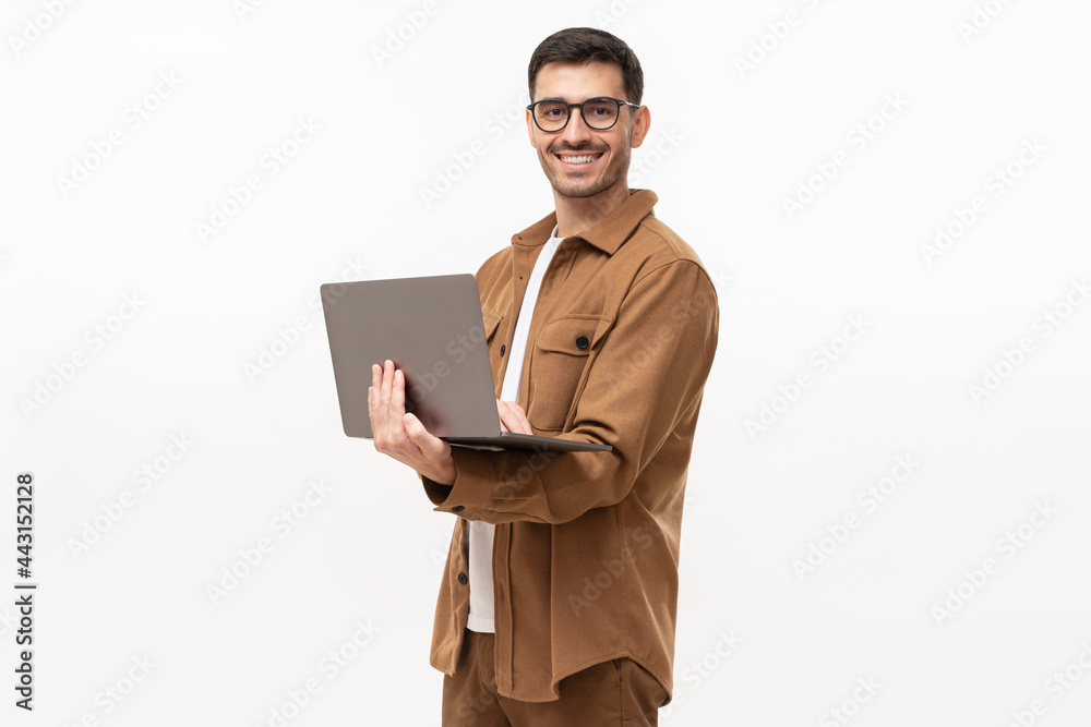 Young man standing holding laptop and looking at camera with happy ...
