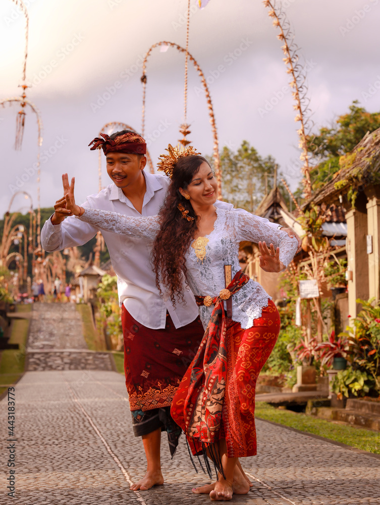 Multicultural couple dancing traditional Balinese dance. Happy couple ...