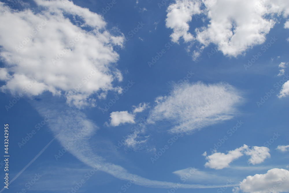 Cumulus and cirrus clouds in the sky. Against the background of a light ...