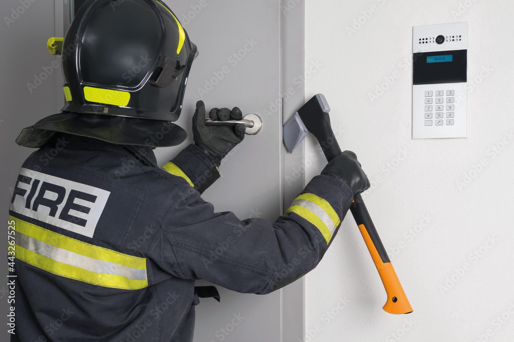 firefighter opens emergency exit door with ax Stock Photo | Adobe Stock