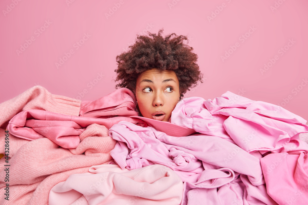 Shocked young Afro American woman shows only head buried in big heap of ...