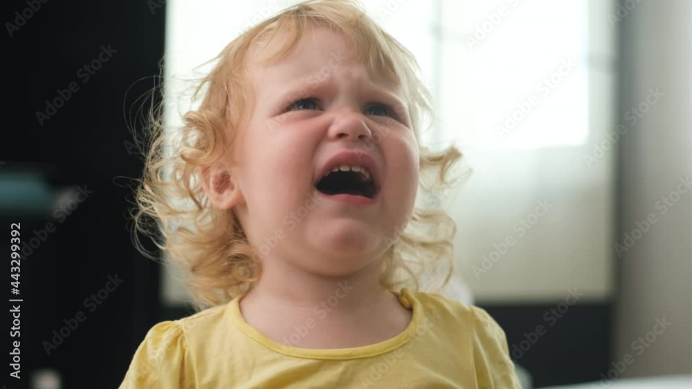 Upset curly haired child crying, portrait. capricious blonde girl in ...