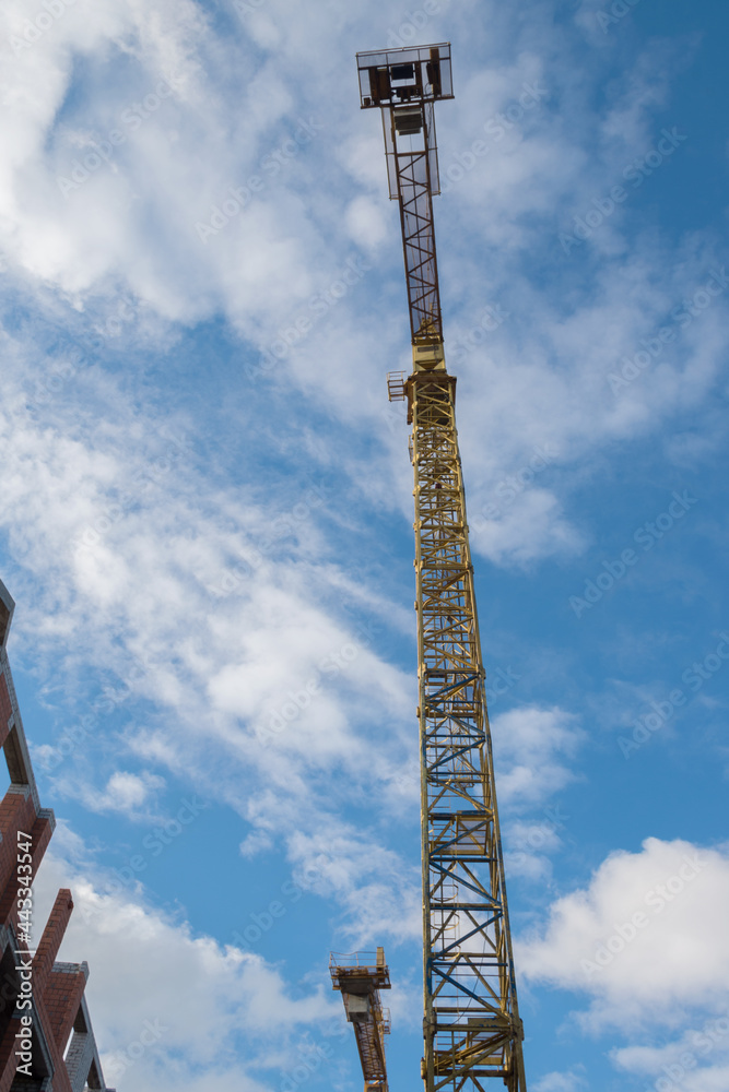 Bottom view of boom of yellow tower crane with frame ties along entire ...