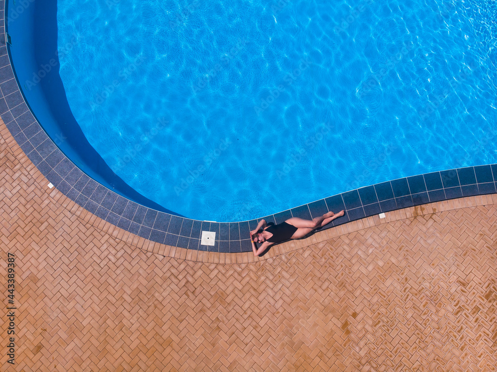 Beautiful woman lying near swimming pool, top view Stock Photo | Adobe ...