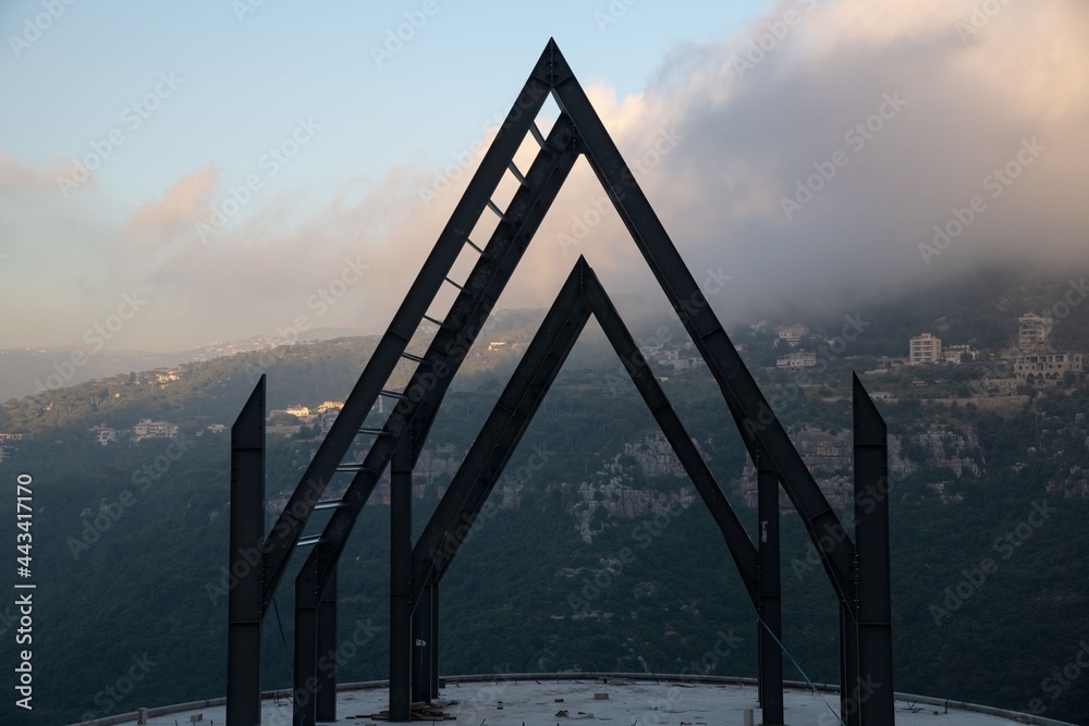 silhouette of an unfinished steel building frame in a rural Lebanon ...