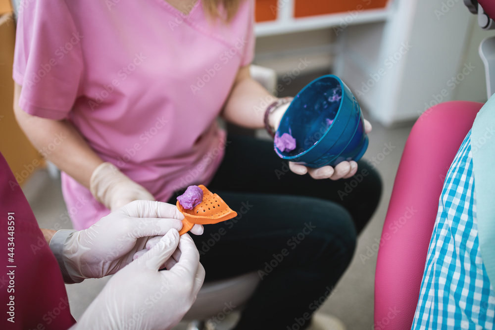 Dentist takes a tooth impression of the patient in the dental office ...