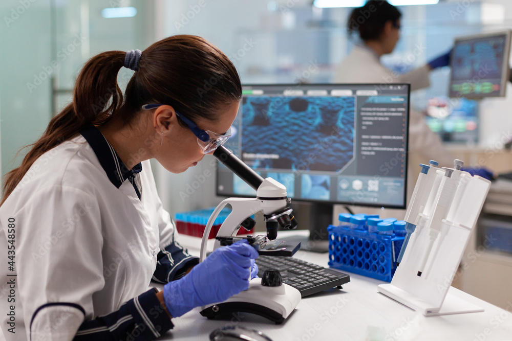 Healthcare scientist researcher vaccine looking at sample through ...