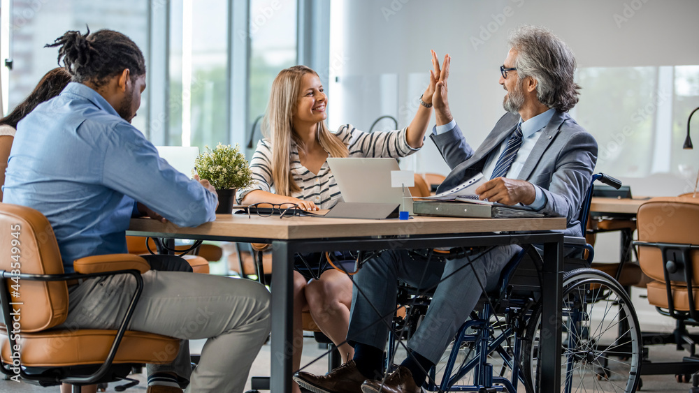 Disabled Male Manager Sitting With His Colleagues At Workplace ...