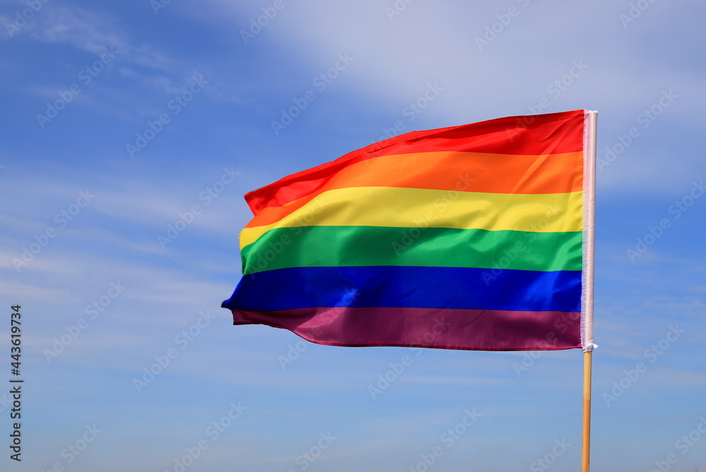 A beautiful rainbow flag of the LGBT organization flies in the sky ...