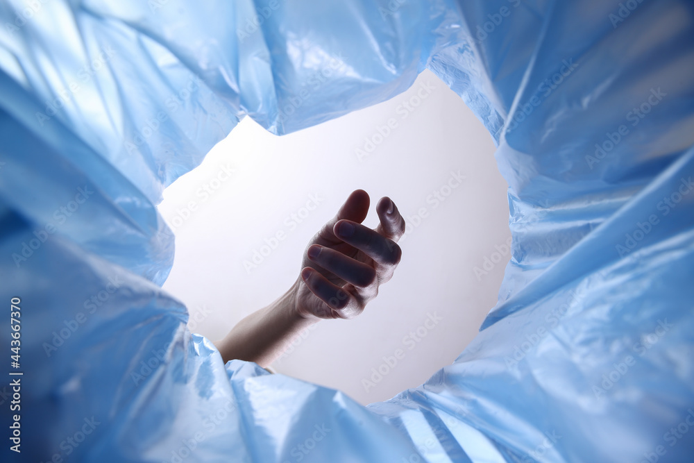 Bottom view hand throwing trash into trash bin with blue bag Stock ...