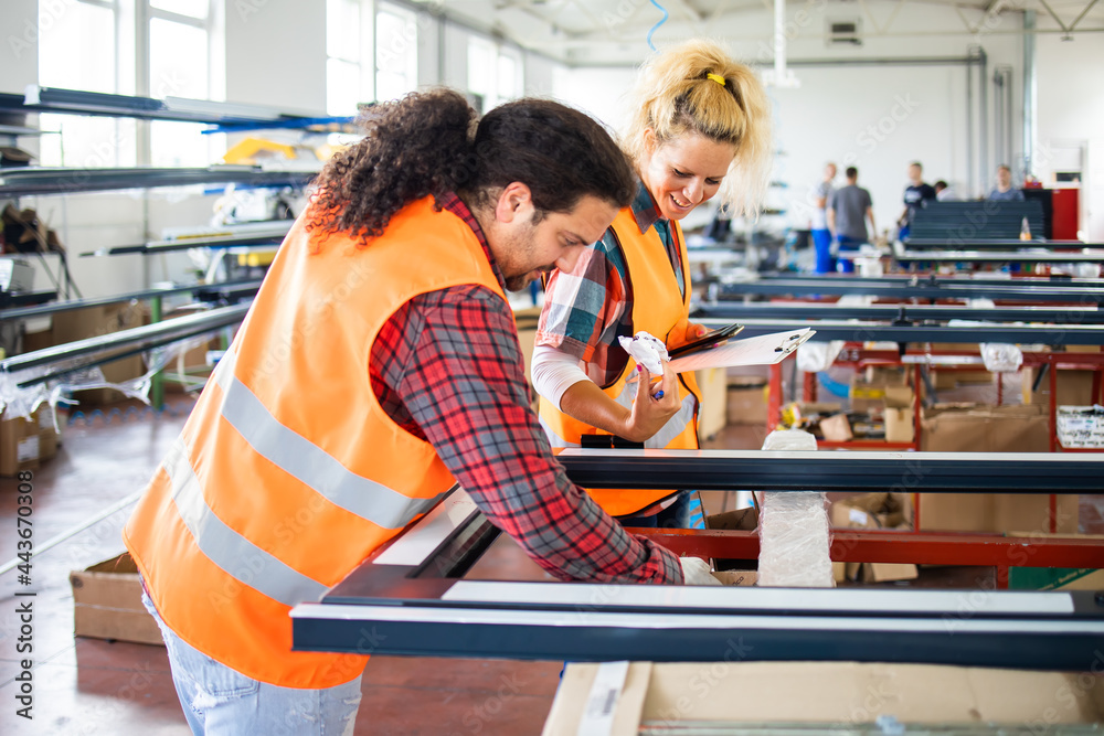 Manual worker assembling PVC doors and windows with his colleague ...