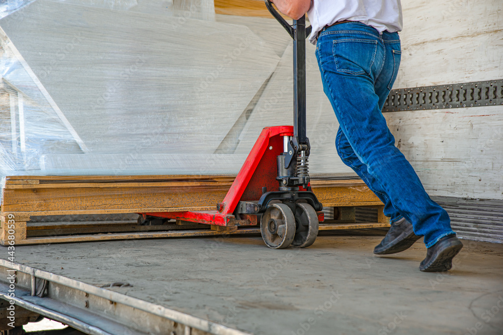 Manual loader. A forklift is towing a hand pallet truck. Folds and ...