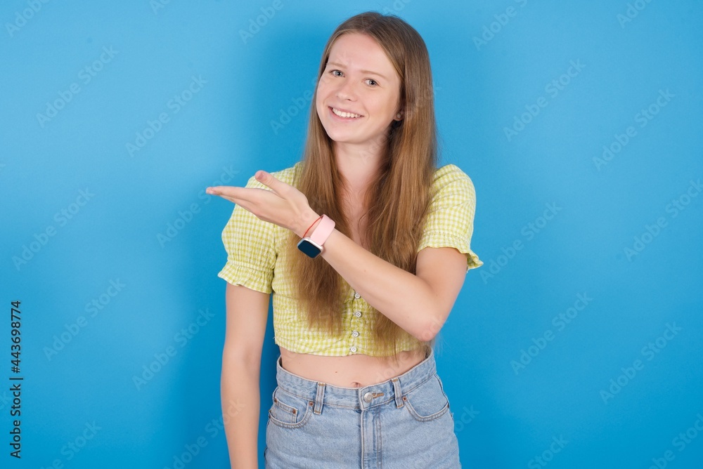 young beautiful blonde woman standing against blue background says: wow ...