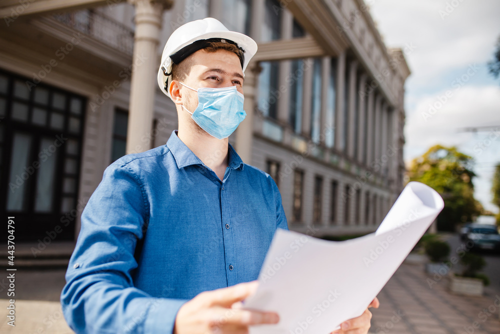 Architect looking at blueprints in a building site. Portrait of an ...