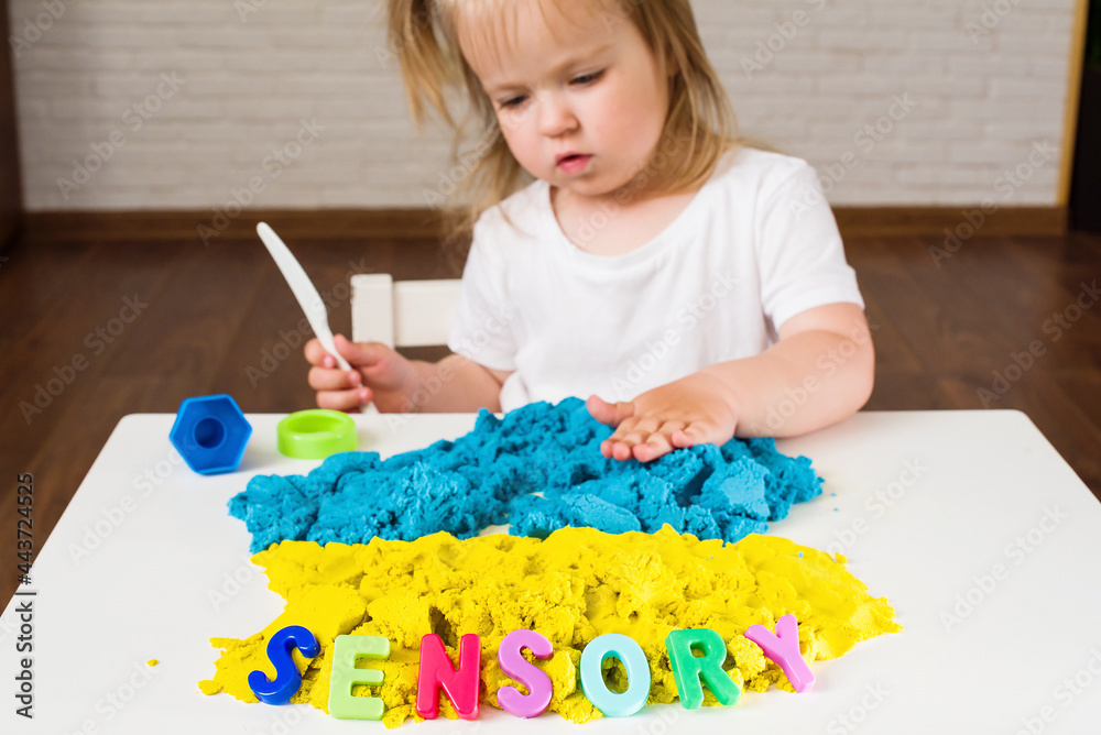 Little girl playing with magic kinetic sand, Sensory word. Early ...