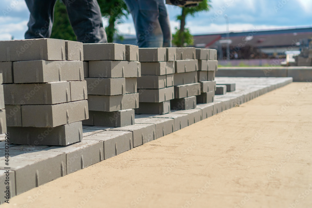 Man's feet are standing near a large number of concrete bricks on the ...