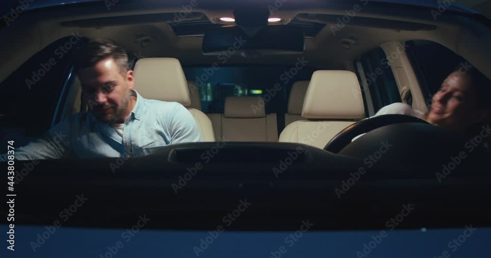 At the night. Front view of the caucasian happy couple sitting into the ...