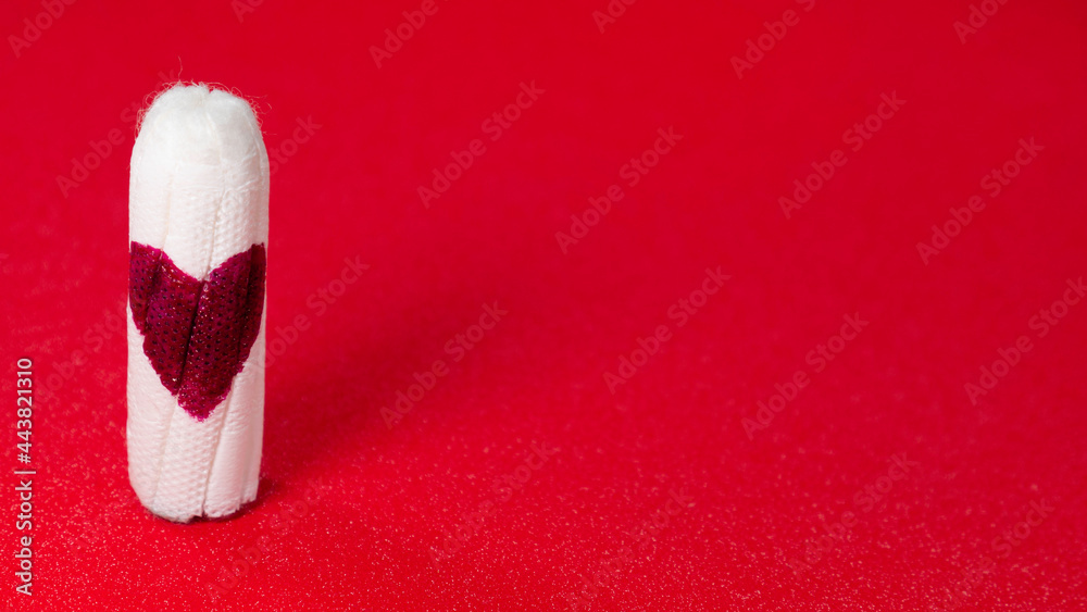 Tampon with heart symbol on red background. Copy space for tex. Female ...