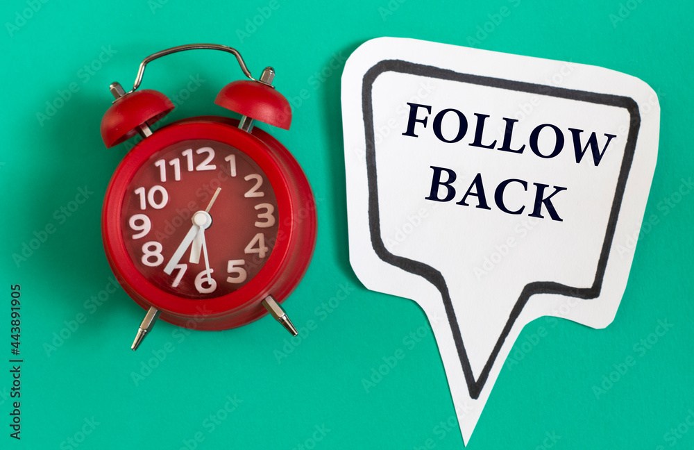 FOLLOW BACK - words on a white note on a green background with a red ...