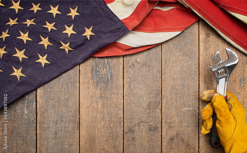Foto de American flag drapped over an old workbench with a hand holding ...