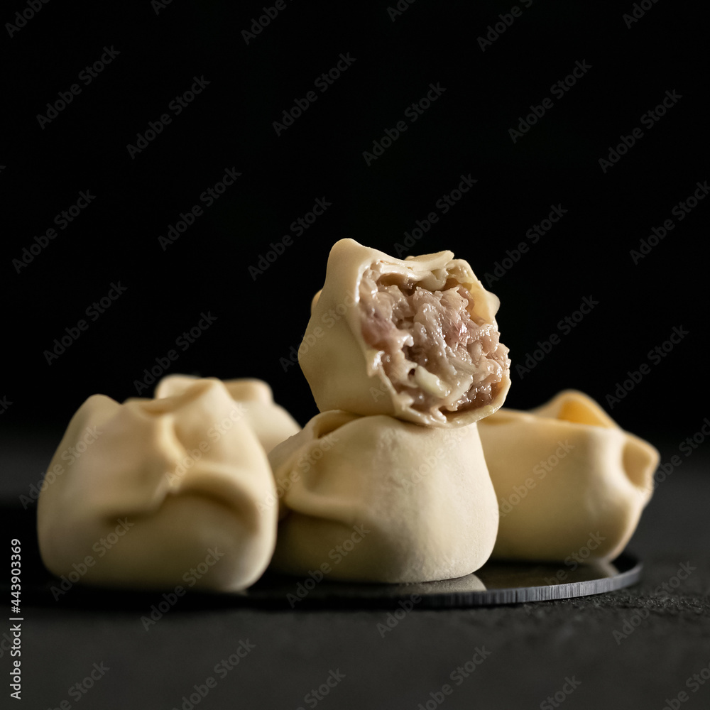 Dumplings stuffed with minced meat on black background. Cooked ...