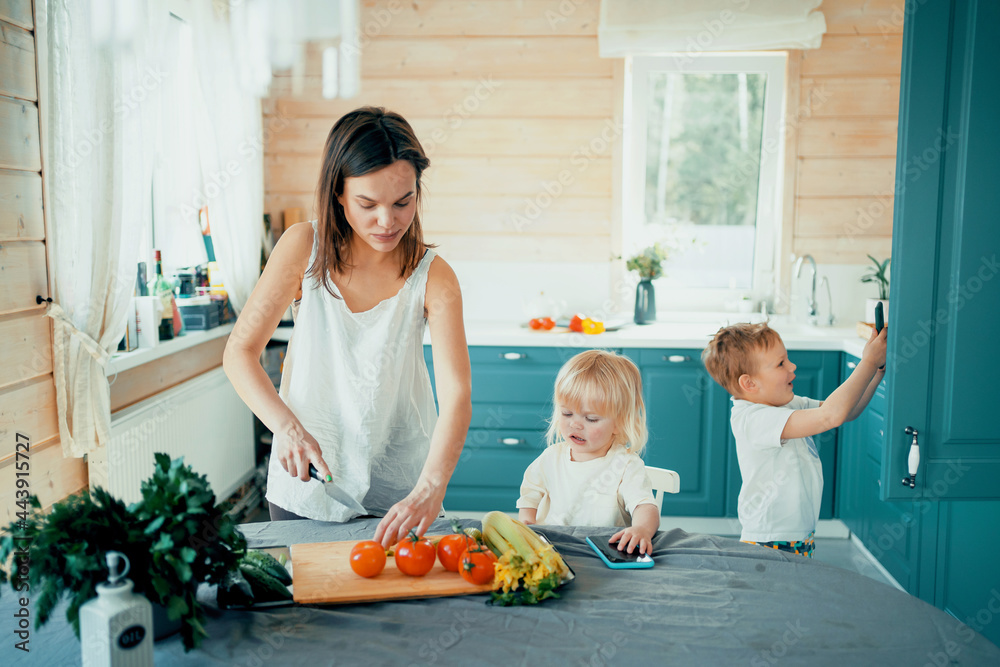 Happy family time fun mood. Children play cooking with their mother in ...