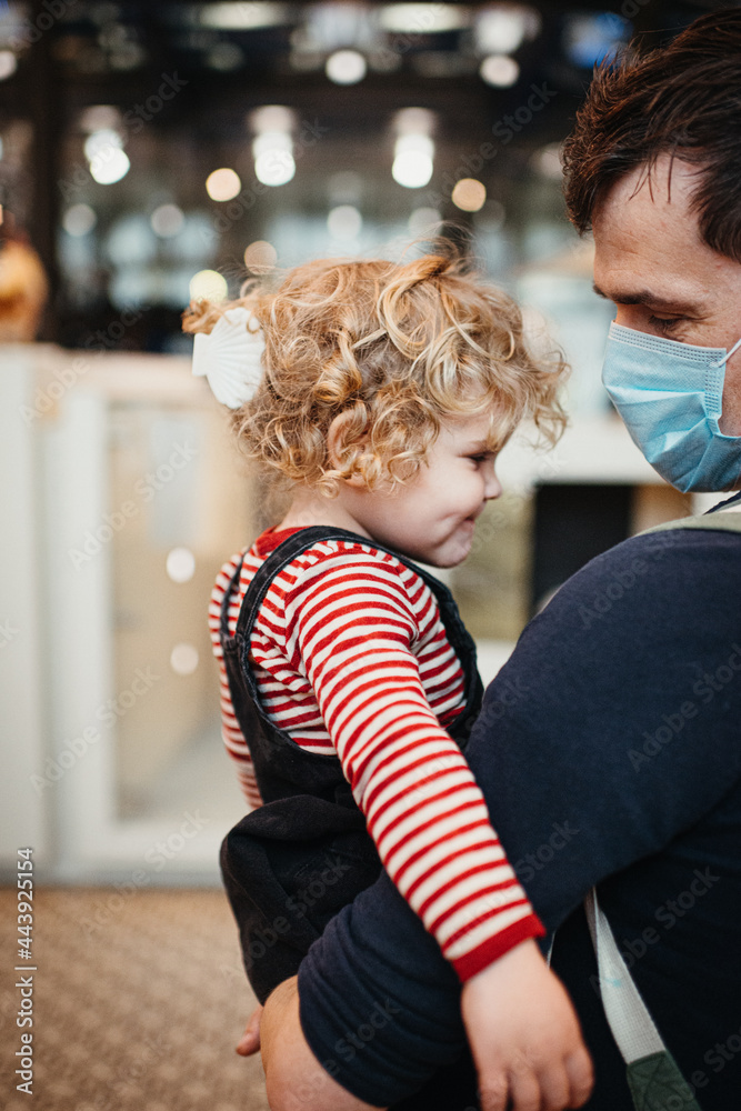 Dad wearing a face mask looking at his daughter Stock Photo | Adobe Stock