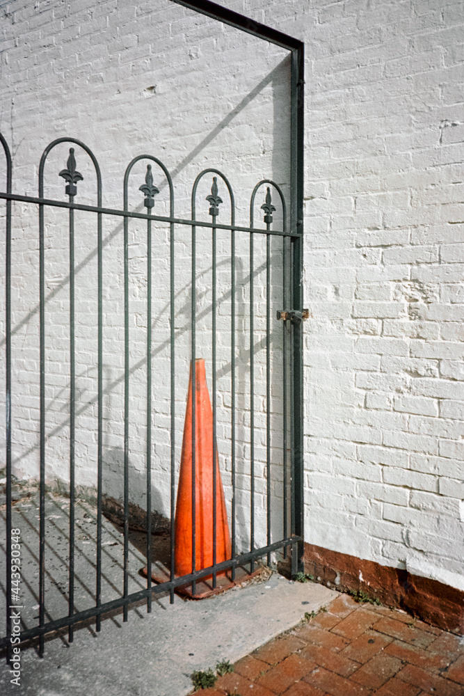 Orange traffic cone behind a gate Stock Photo | Adobe Stock