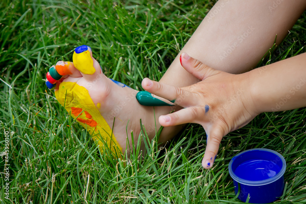 The child draws a pattern on the leg. A funny drawing with bright ...