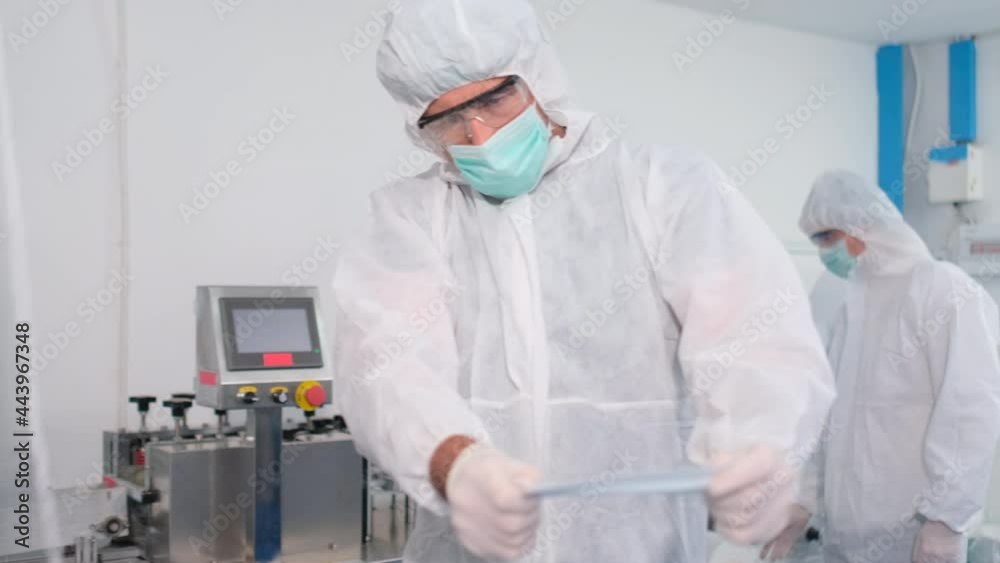Close up factory man with ppe suit check the quality of face mask ...