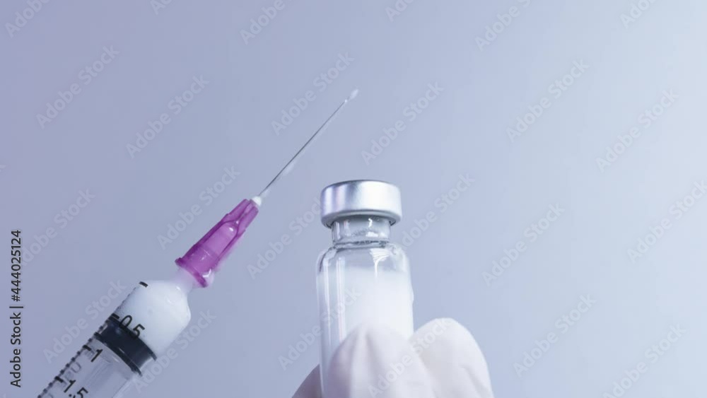 Close up nurse doctor use syringe injection needle sucking liquid ...
