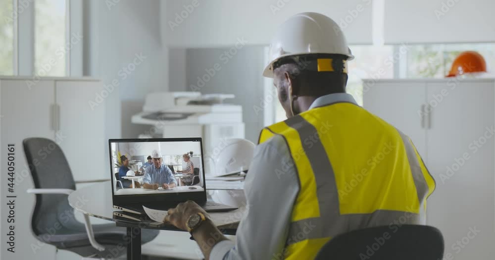 Back view of afro-american male engineer having video chat with foreman ...