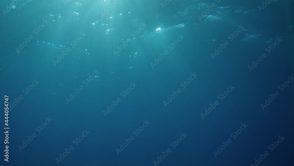 Sun beams penetrating wavy ocean surface. Ocean background light shafts ...