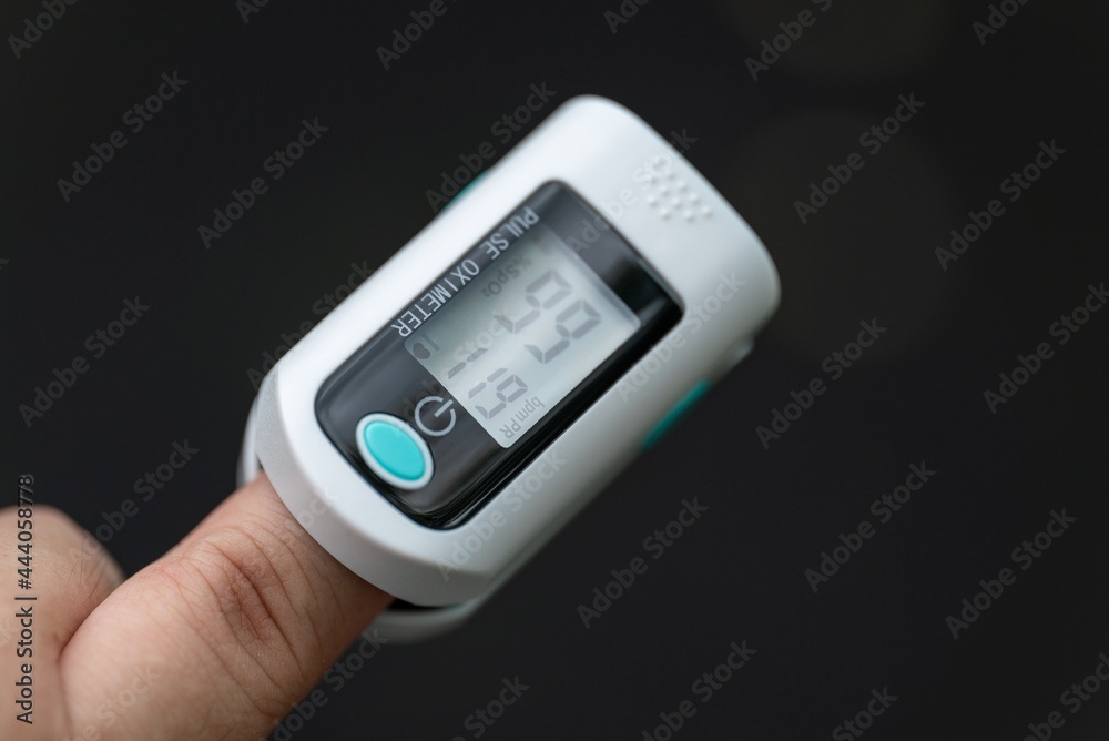 Asian Man measuring oxygen level with modern fingertip pulse oximeter ...
