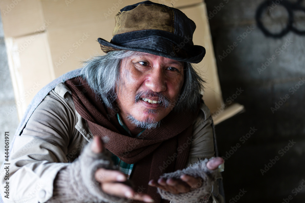Homeless elderly man with brown hair, bearded, mustaches, hat, gloves ...