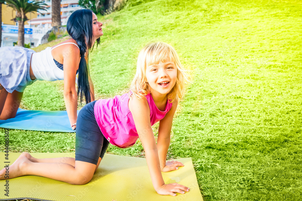 Cute happy little girl in sportswear smiling at camera while while ...