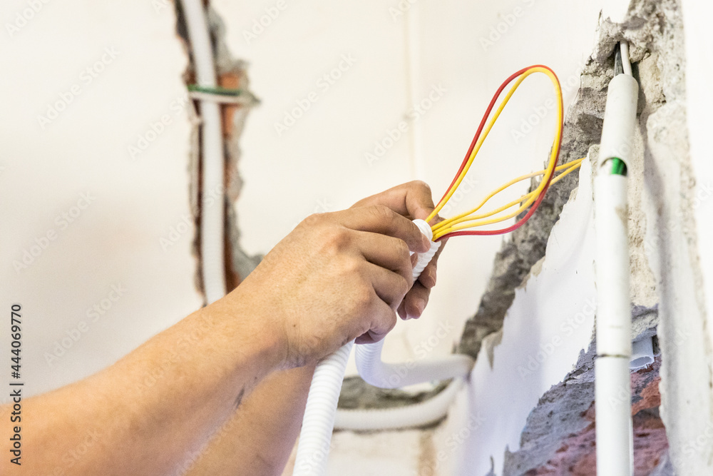 Foto de Electrician concealing electicity power wire lines within ...