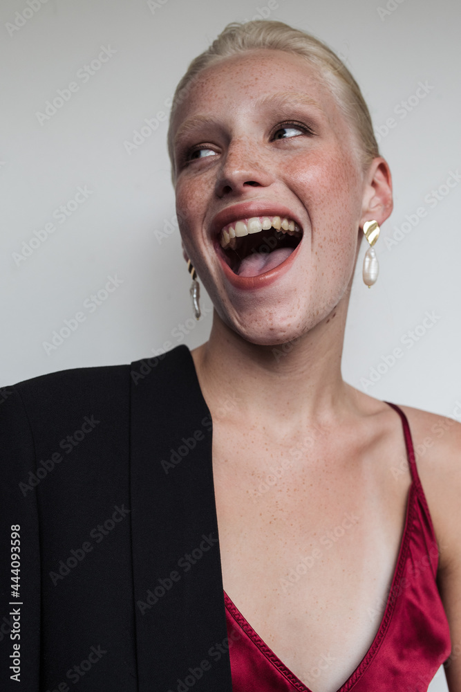 Fashion model laughing hard while wearing red top, black blazer and ...