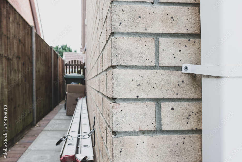 Shallow focus of an external house wall and part of the PVC down gutter ...