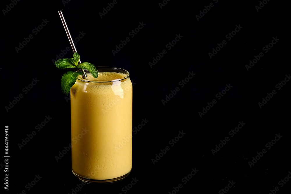 Mango lassi in glass with tube on black background. Traditional Indian ...