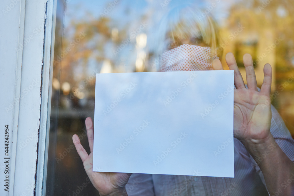 Elderly woman in quarantine holds blank note on window Stock Photo ...