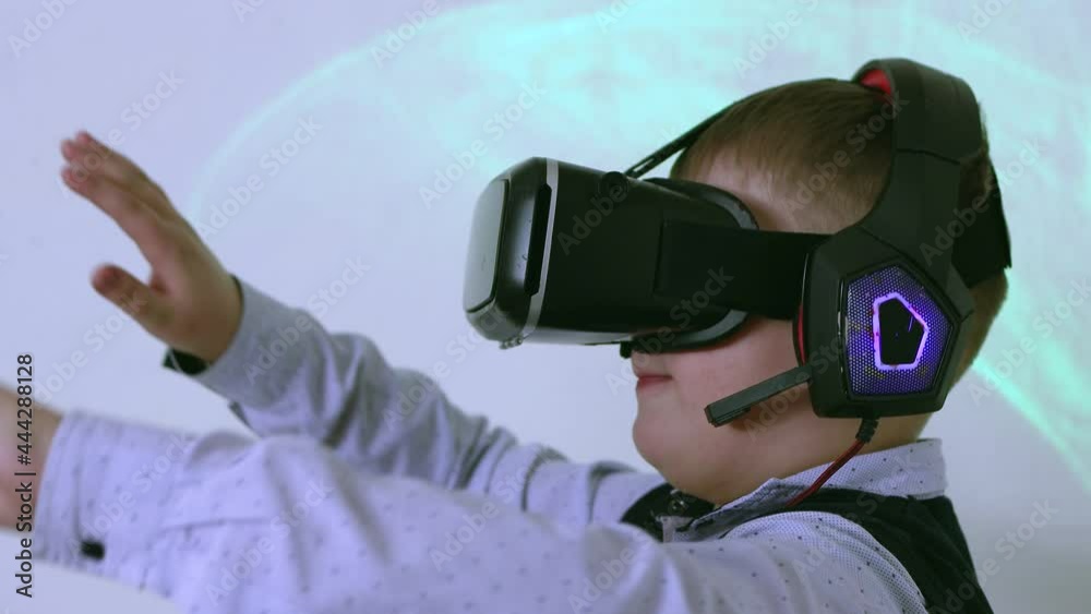 A boy in an augmented reality headset in profile moves his arms. Close ...