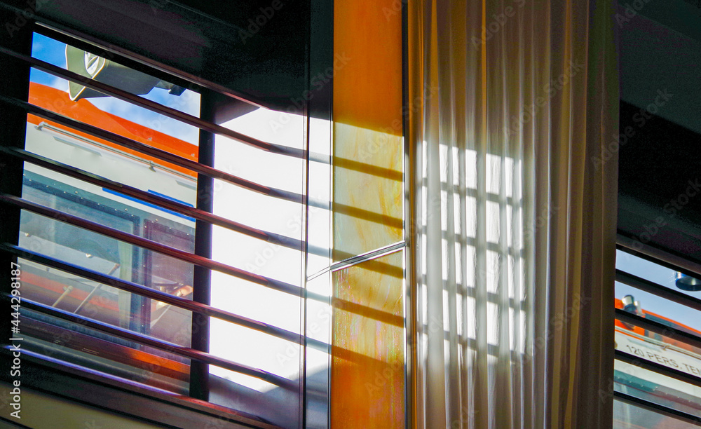 Light and shadow through window looking onto life boat of cruiseship ...