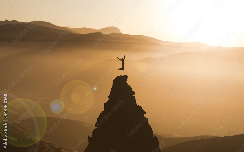 Young Woman jumping On top Of Mountain Peak Celebrating Success ...