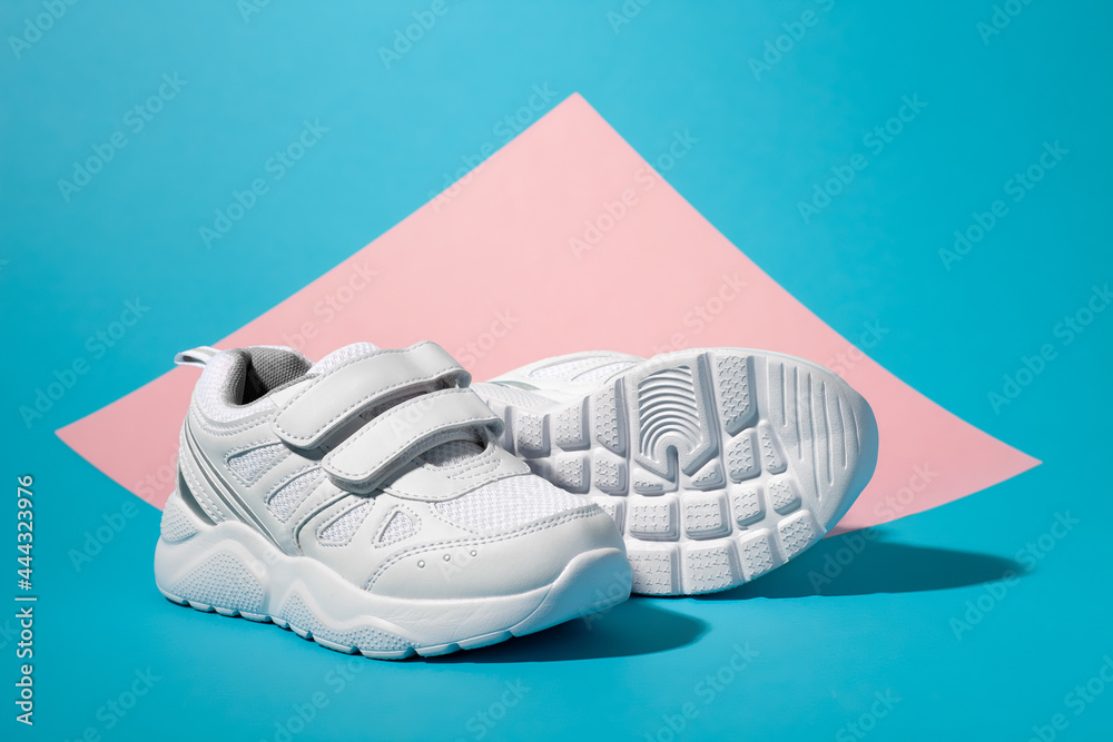 macro, side view one white girl sneaker stands in front of a second ...